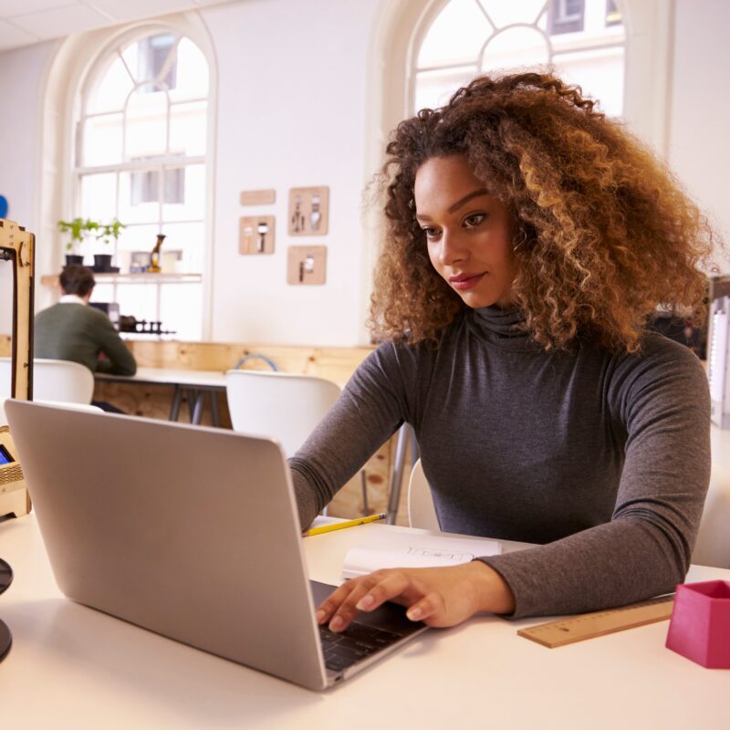 Female Designer Working With 3D Printer In Design Studio